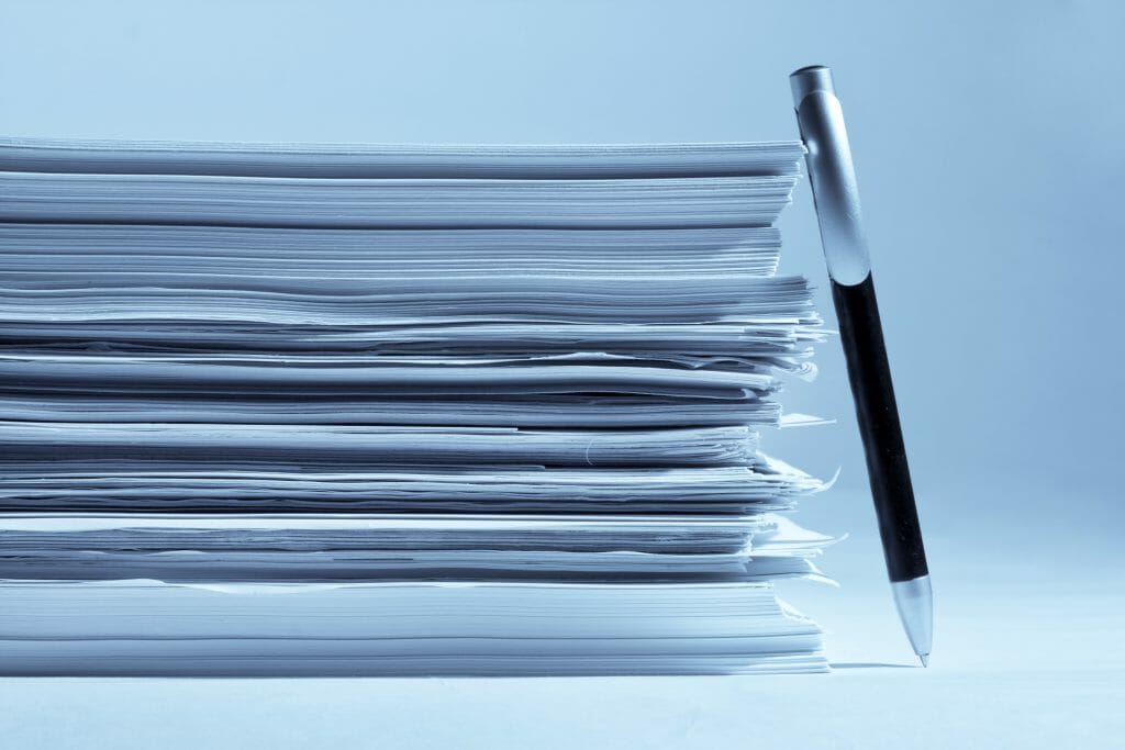 a pen near stack of paper – Global Document Services, LLC